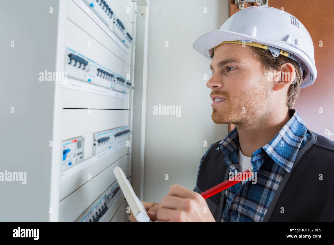 young electrician working on electric panel Stock Photo - Alamy