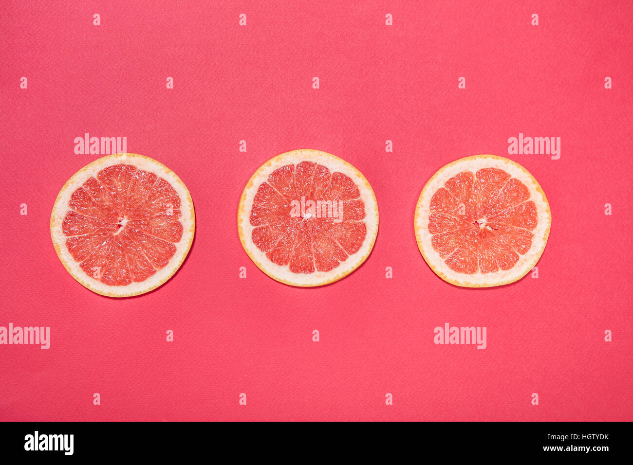 Cross sections of grapefruit against orange background Stock Photo - Alamy