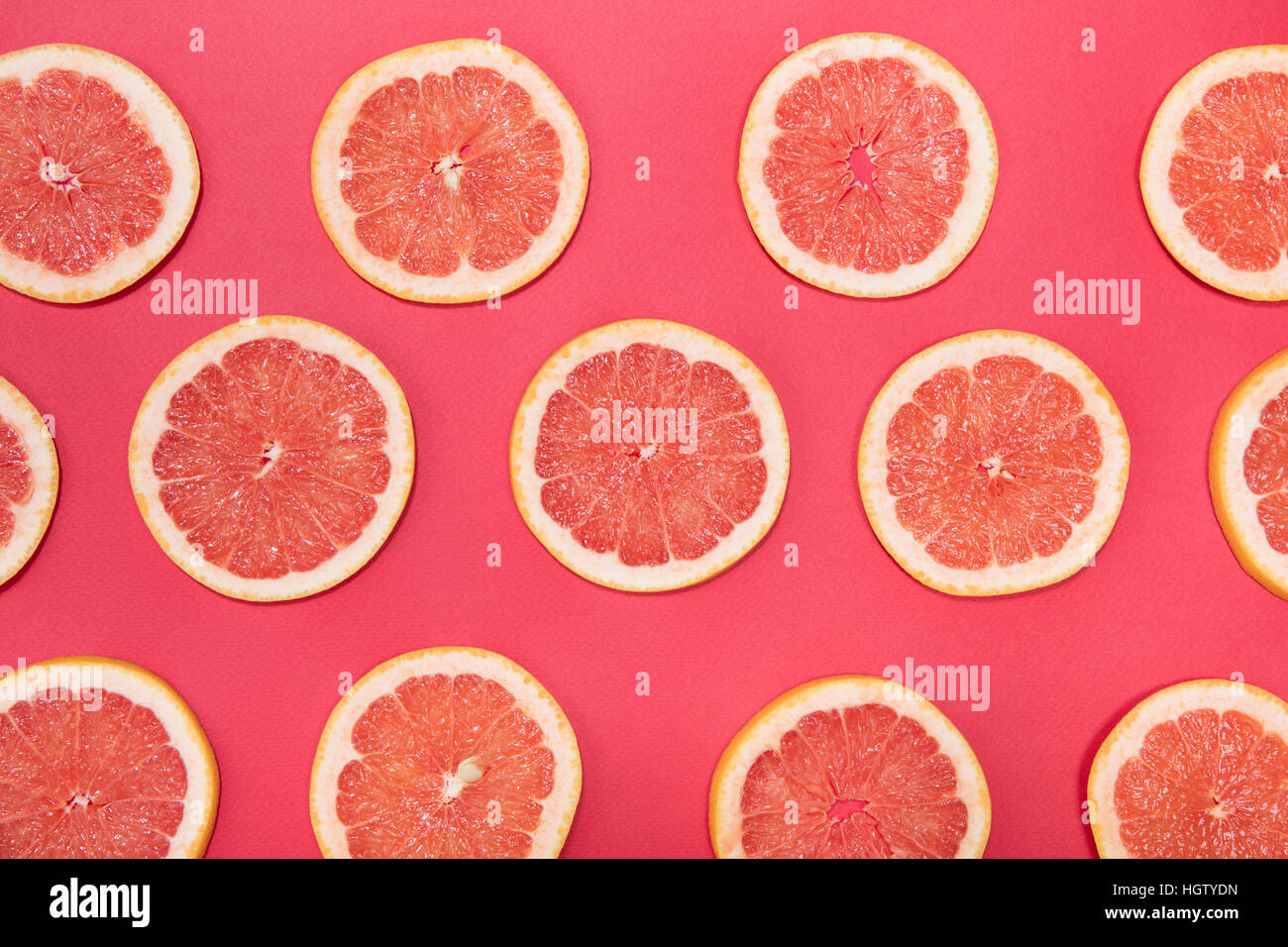 Cross sections of grapefruit against orange background Stock Photo - Alamy