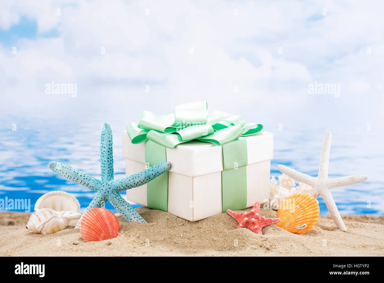 Seashells and present box on beach against summer sea Stock Photo - Alamy