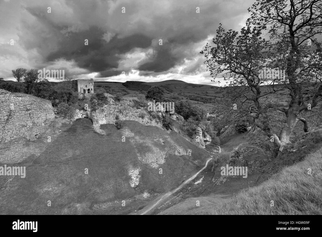 Summer view through Cave Dale with the ruins of Peveril Castle ...