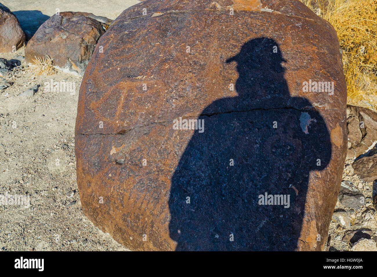 Photographer's shadow with petroglyphs pecked into basaltat BLM's ...