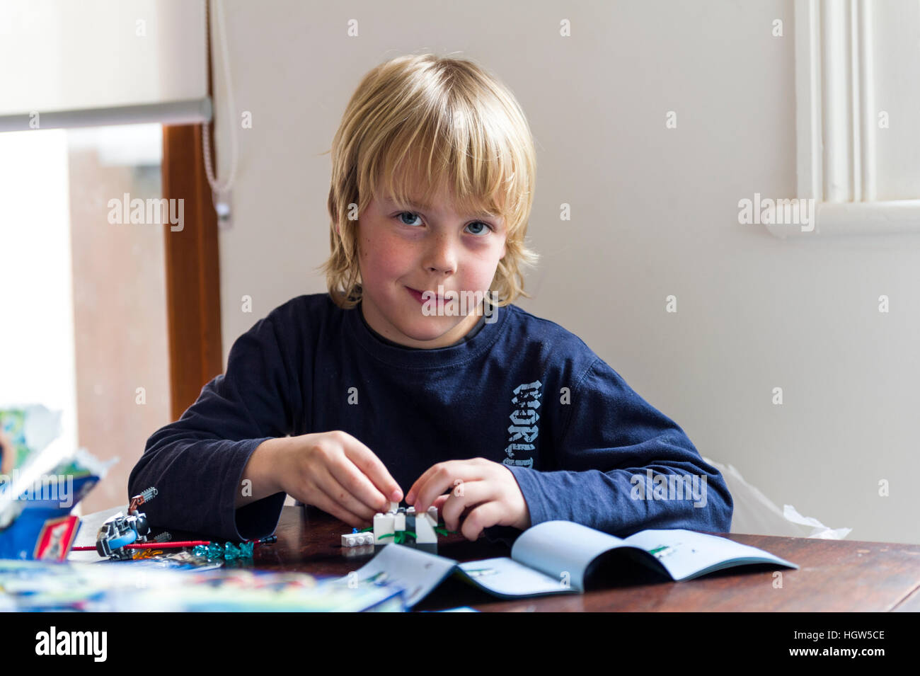 A boy constructing Lego at a dining table Stock Photo - Alamy