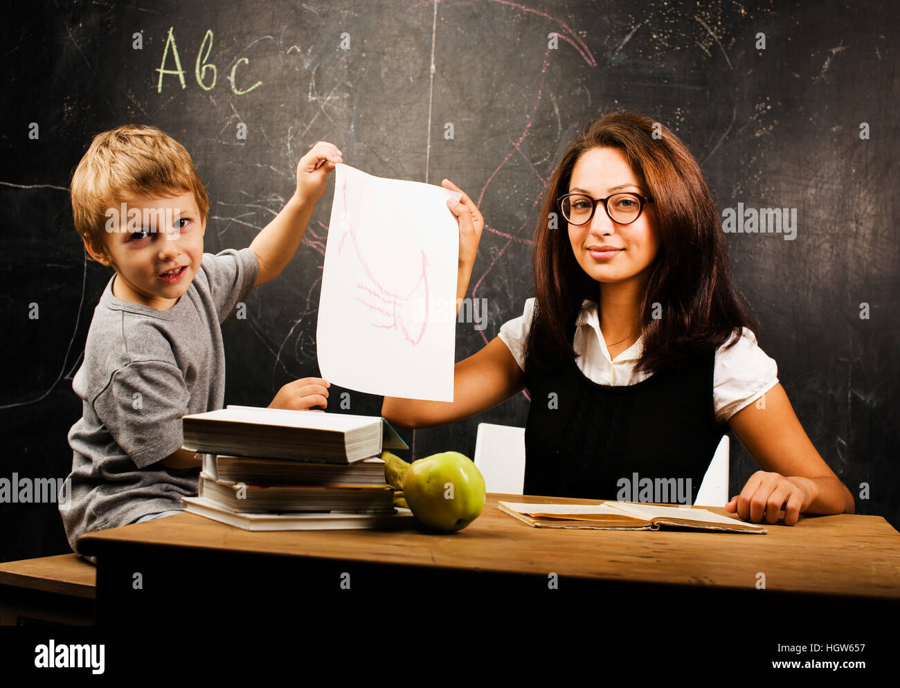 little cute boy with young teacher in classroom studying at blac Stock ...