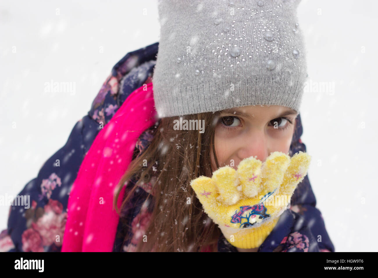 Little girl eating snow of her glove Stock Photo - Alamy