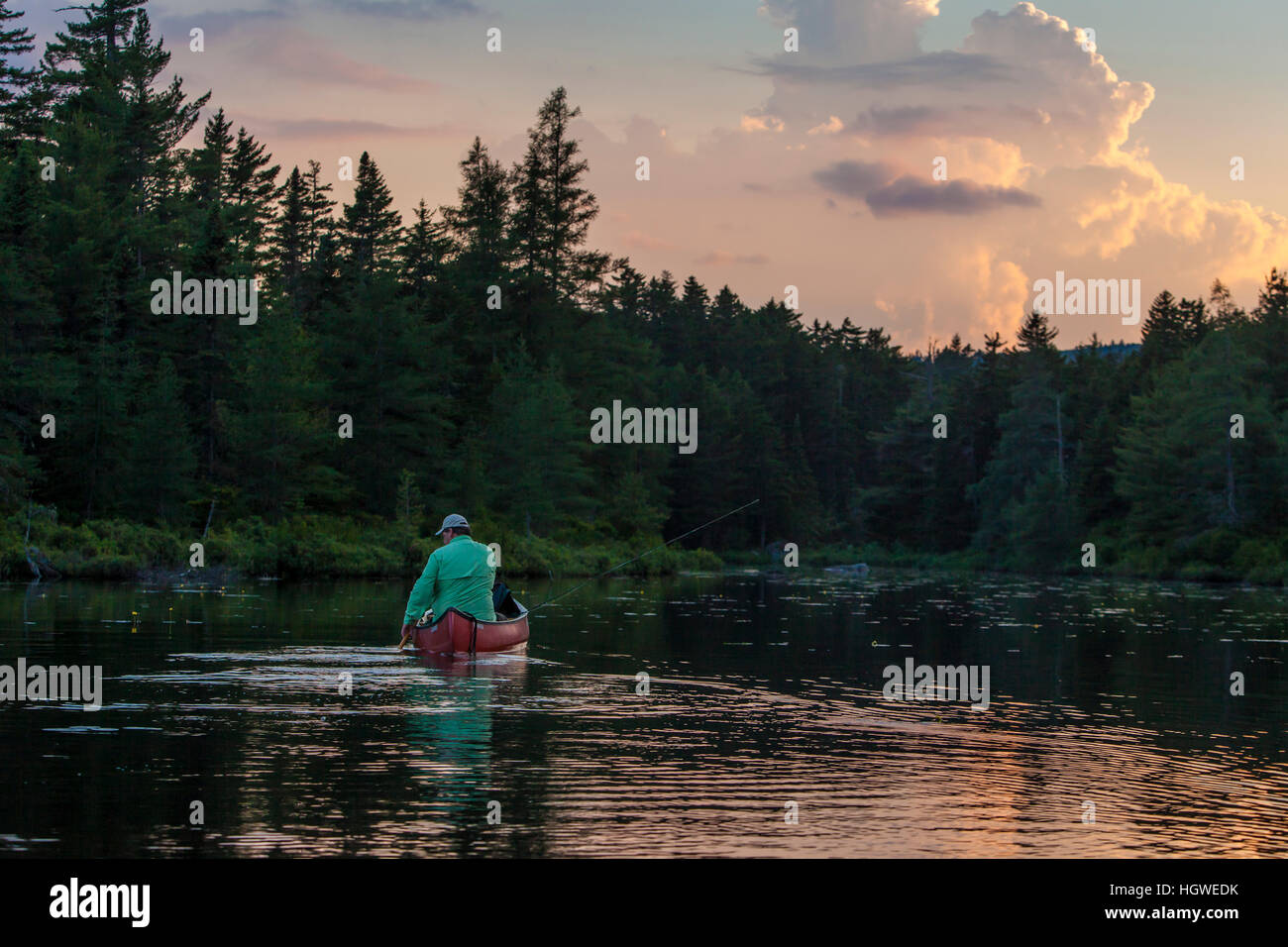 A man fly-fishing on Little Berry Pond in Maine's Northern Forest. Cold ...