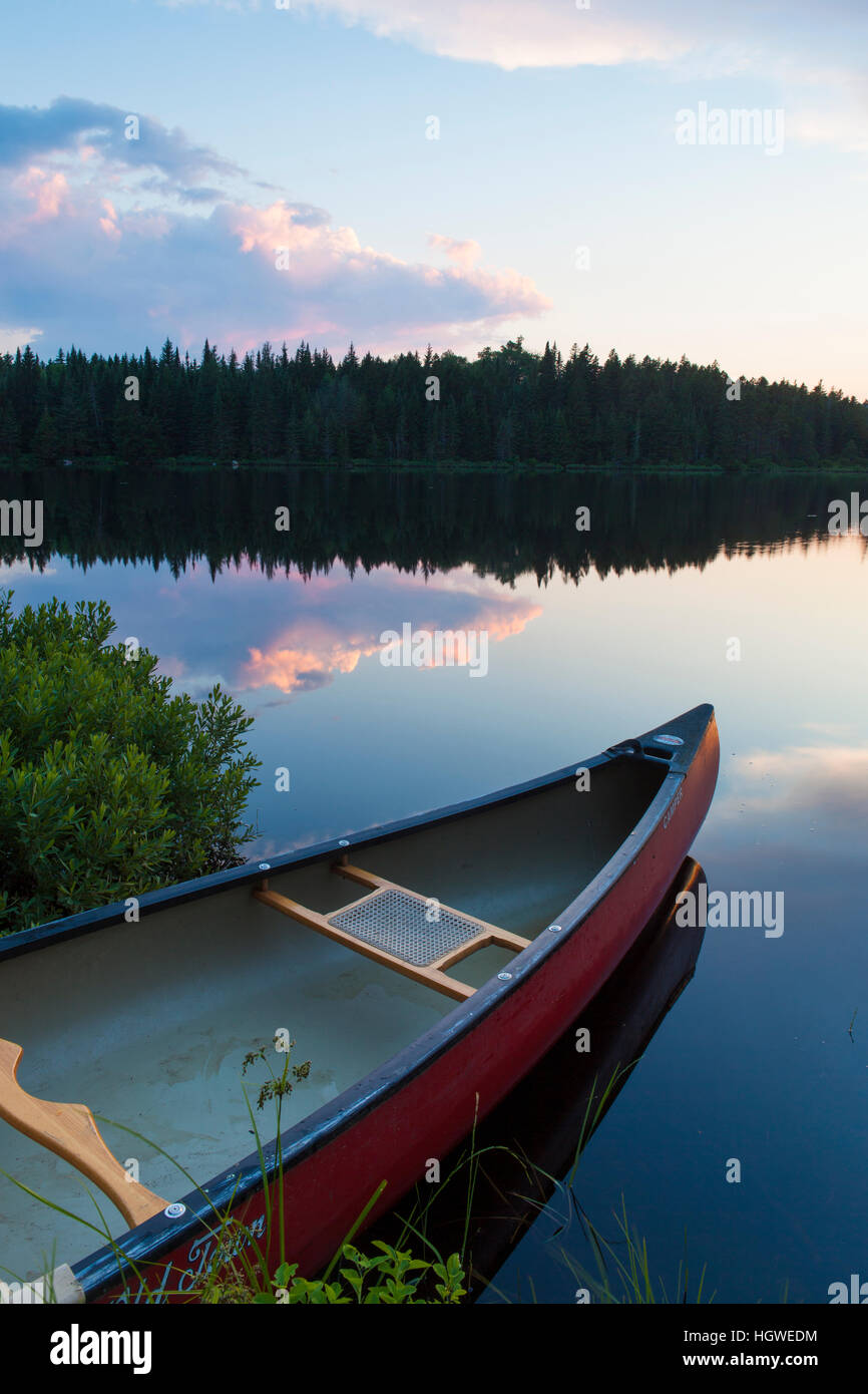 A canoe on Little Berry Pond in Maine's Northern Forest. Sunset. Cold ...
