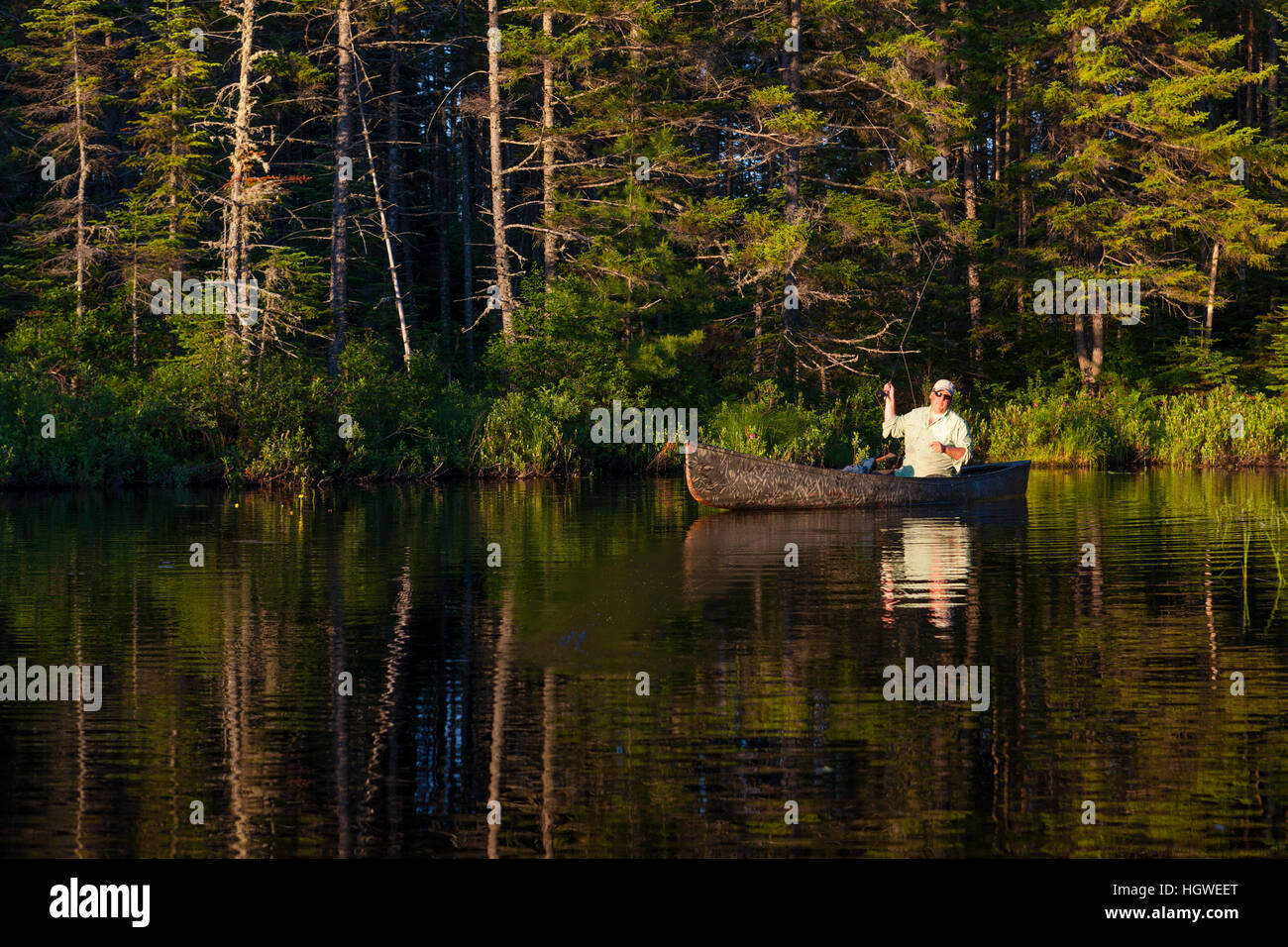 A man fly-fishing on Little Berry Pond in Maine's Northern Forest. Cold ...