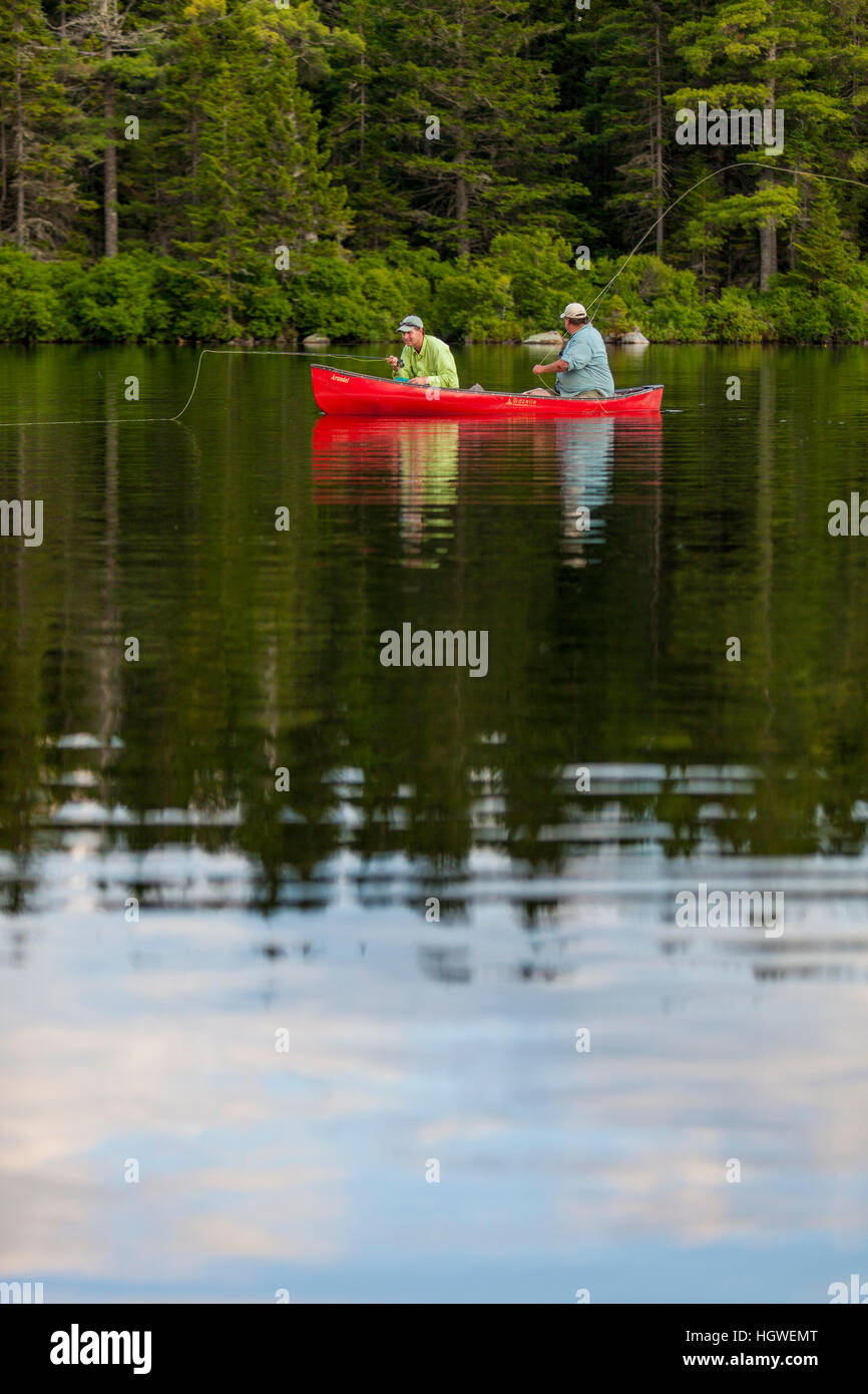 Two men fly-fishing for brook trout from a canoe on Lang Pond in Maine ...