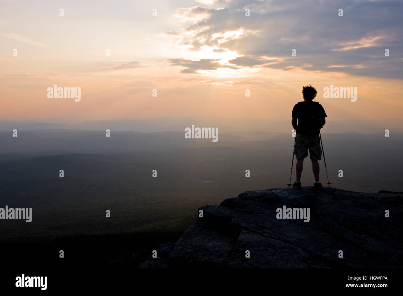A man watches the sunset on the summit of Mount Monadnock in Monadnock ...