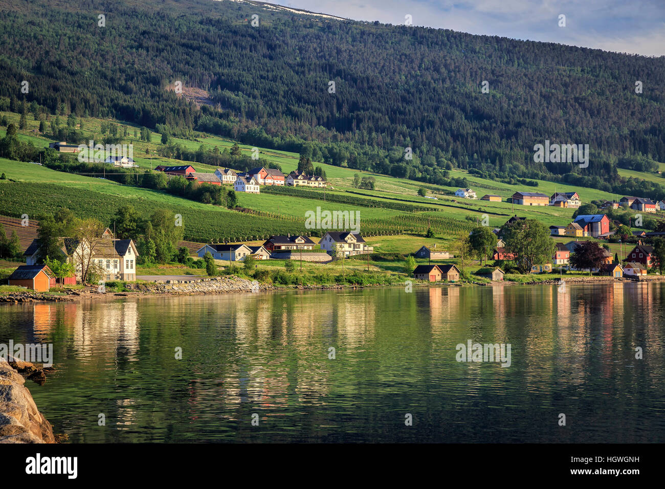 An late in the day photo of the houses and farms that line the fjord in ...
