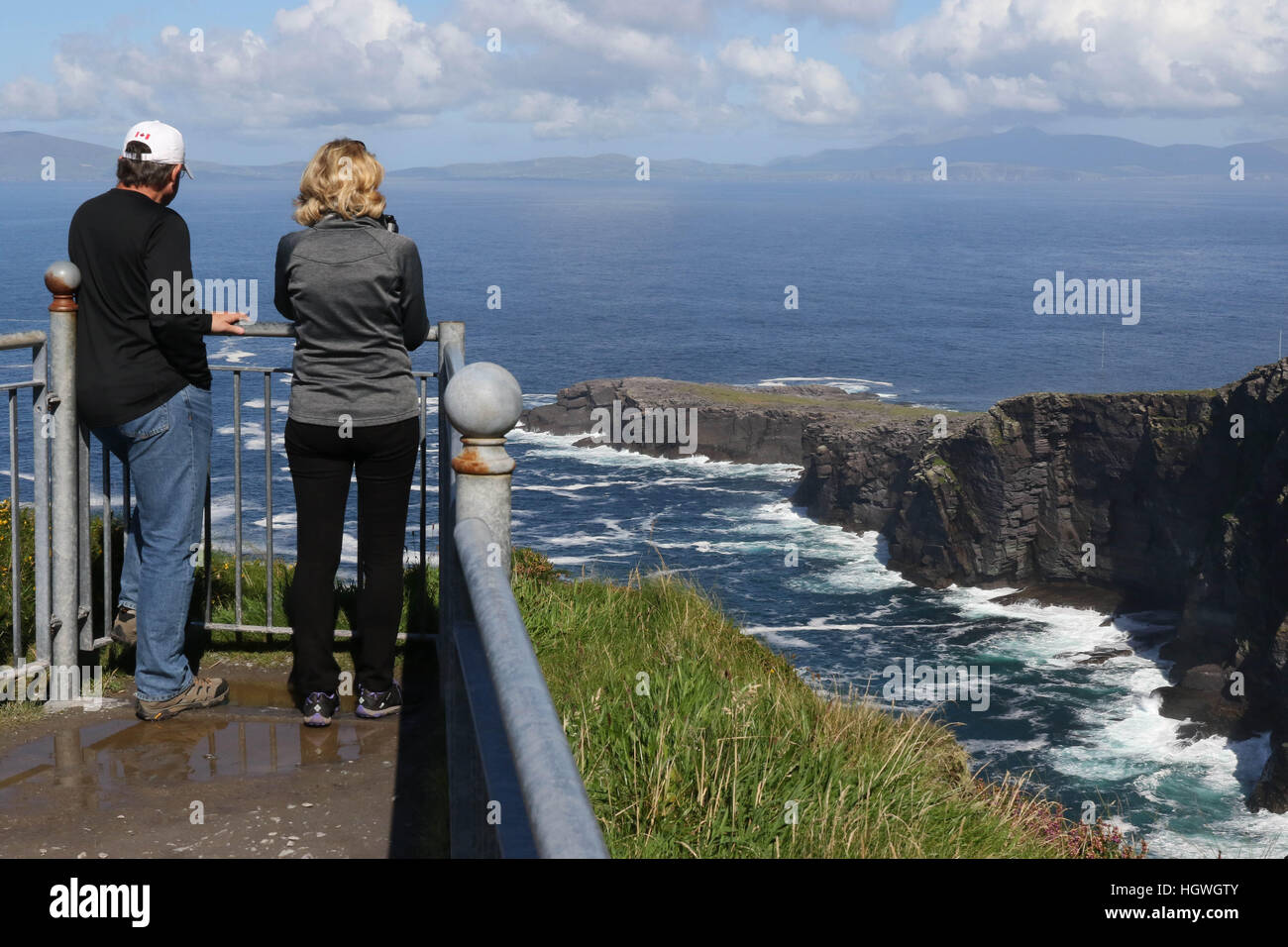 Man and women taking photograph of the west coast of Ireland with white ...