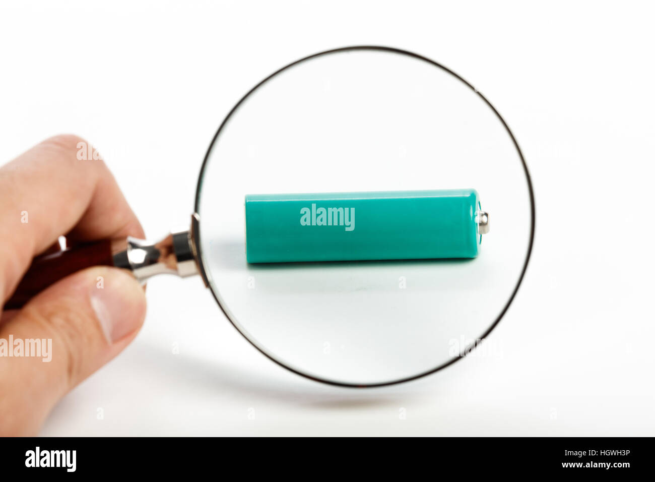 green battery and magnifying glass with white background, close up ...