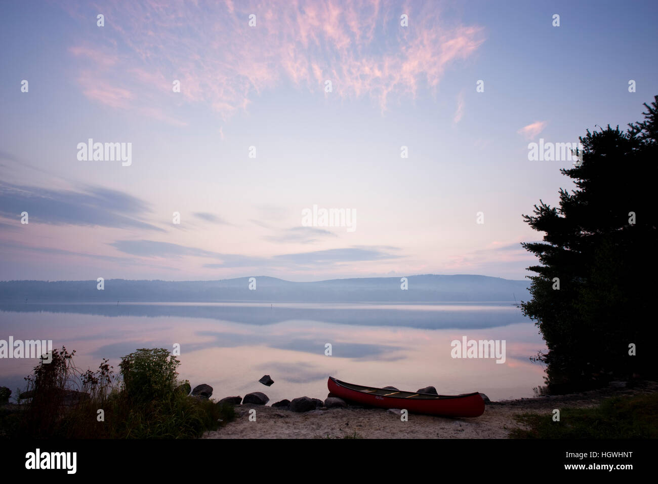 A canoe on the shoreline of Lake Sunapee at sunrise at Mount Sunapee ...