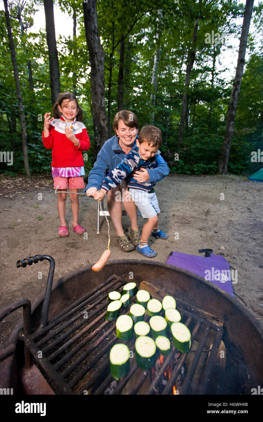 A woman and her kids cook over the fire while camping in Crawford Notch ...