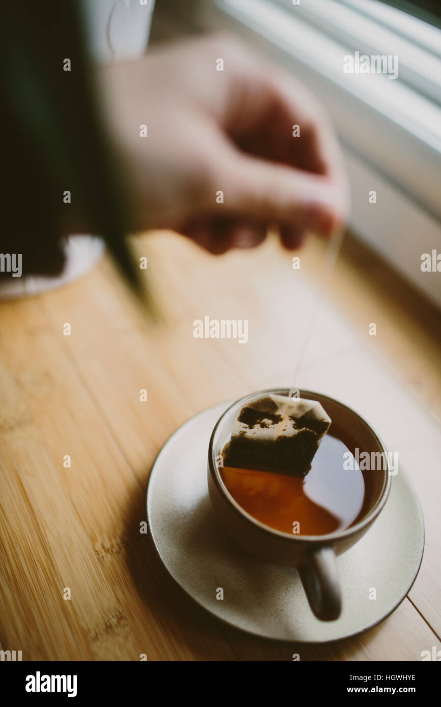 person making tea in windowsill Stock Photo - Alamy
