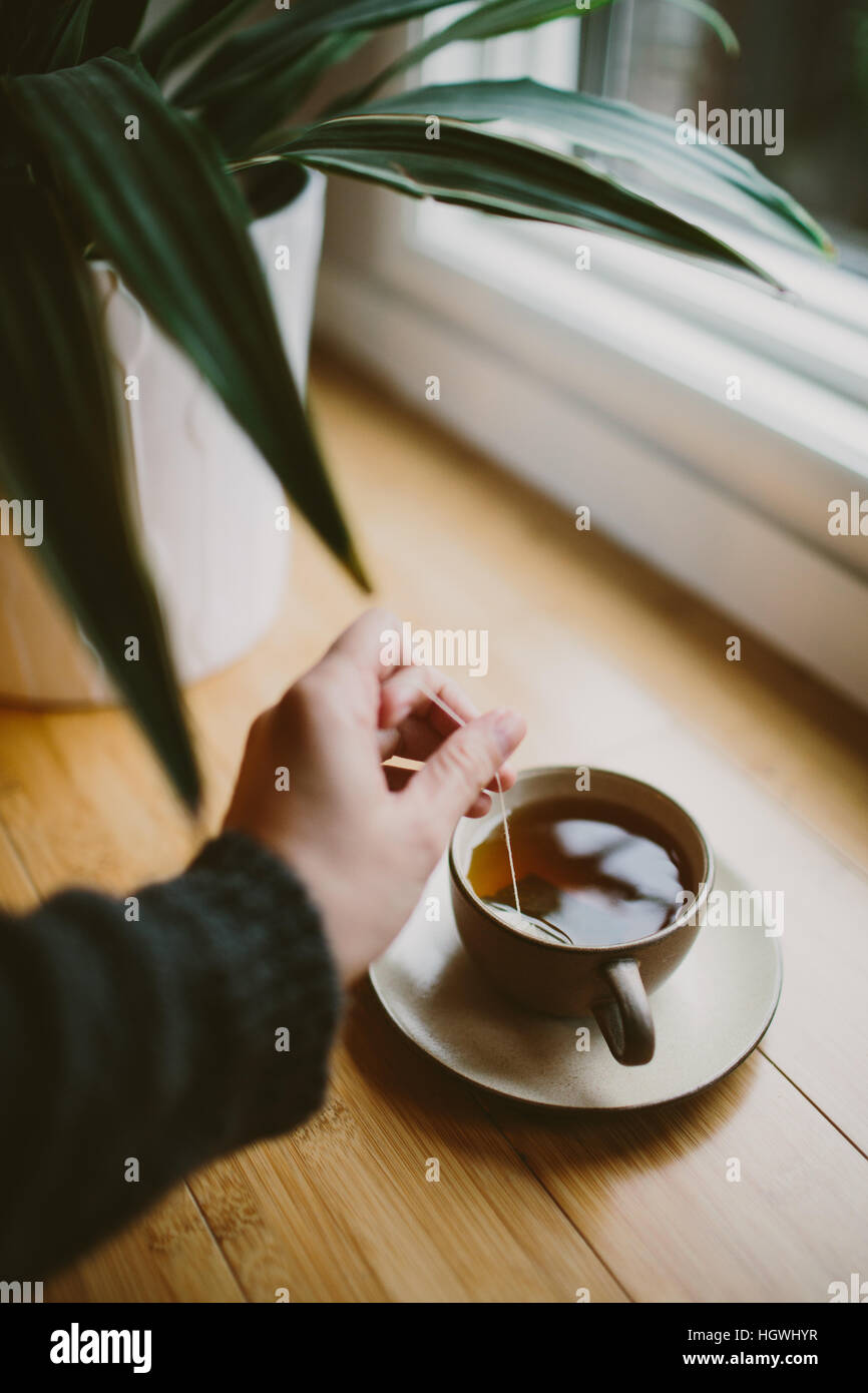 person making tea in windowsill Stock Photo - Alamy
