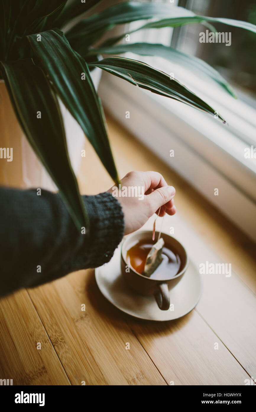 person making tea in windowsill Stock Photo - Alamy