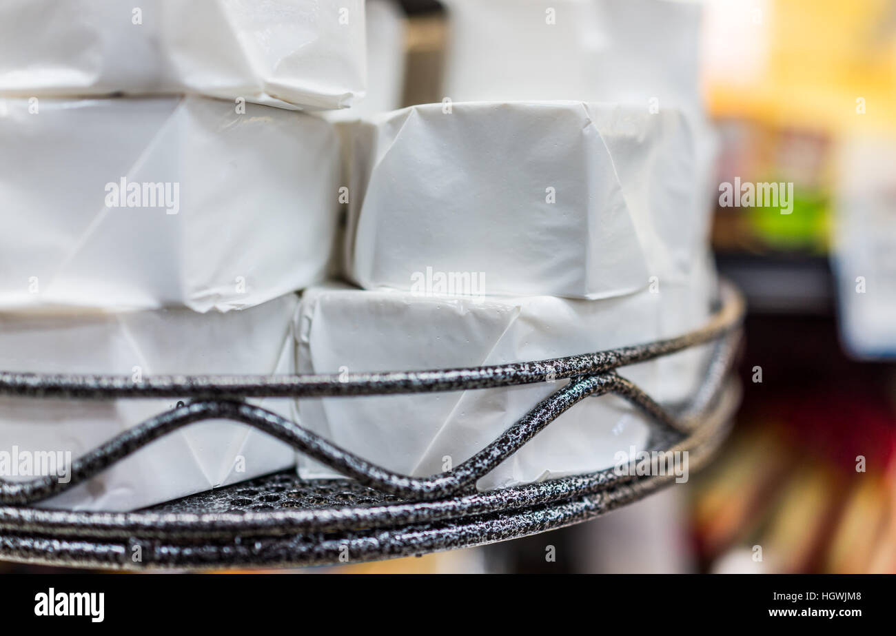 Many packages of brie wrapped in white paper on display Stock Photo - Alamy