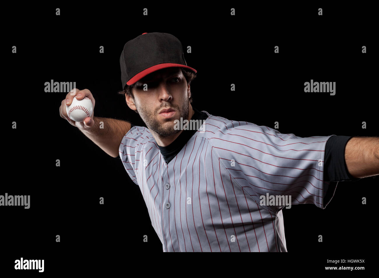 Baseball Player pitching a ball on a black background. Studio Shot ...