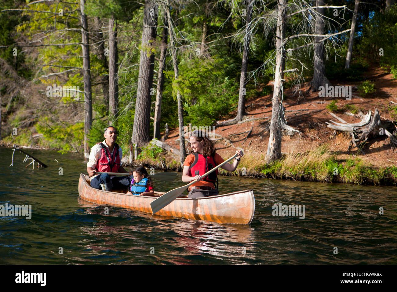 A man, woman, and young girl canoe on Zack Woods Pond in Hyde Park ...