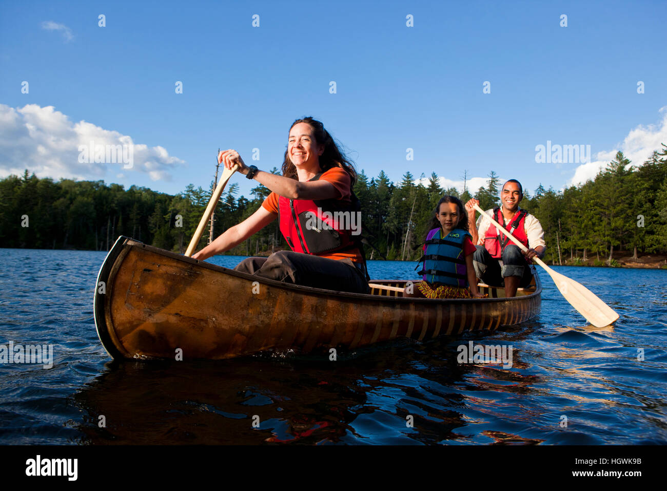 A man, woman, and young girl canoe on Zack Woods Pond in Hyde Park ...