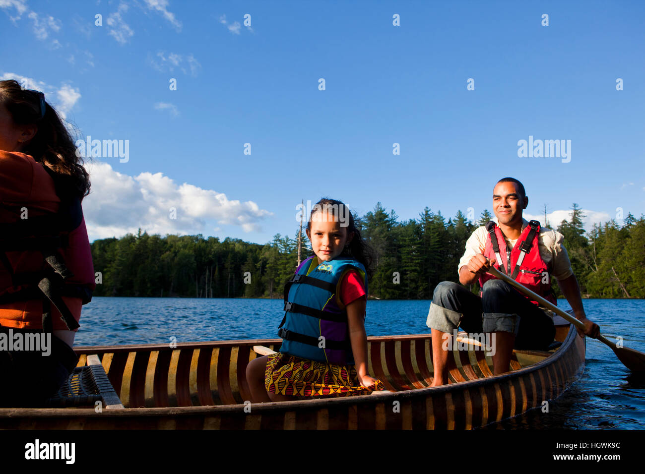 A man, woman, and young girl canoe on Zack Woods Pond in Hyde Park ...