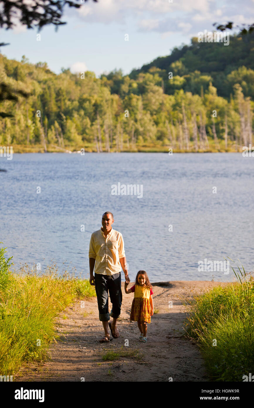 A man and his young daughter walk on a path to Mud Pond in Zack Woods ...