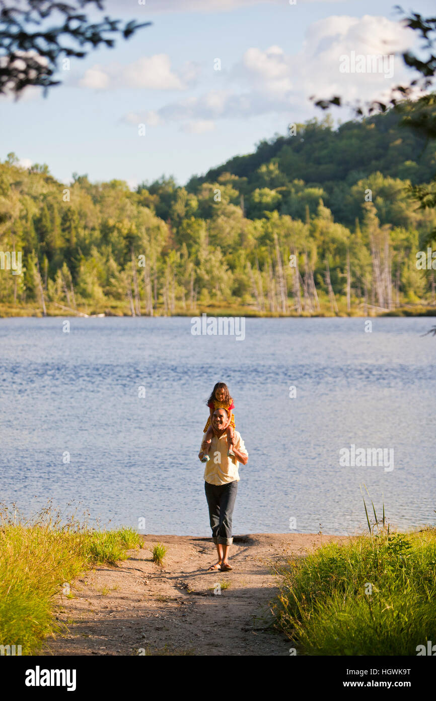 A man and his young daughter walk on a path to Mud Pond in Zack Woods ...