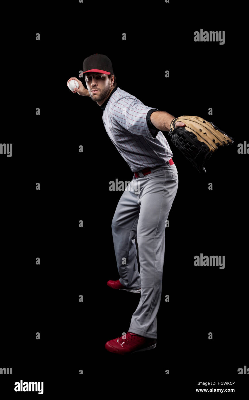 Baseball Player pitching a ball on a black background. Studio Shot ...