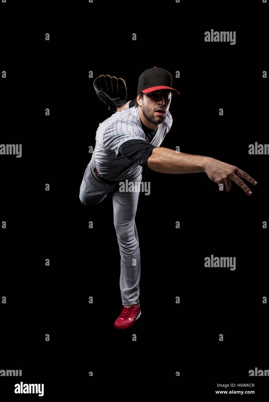 Baseball Player pitching a ball on a black background. Studio Shot ...