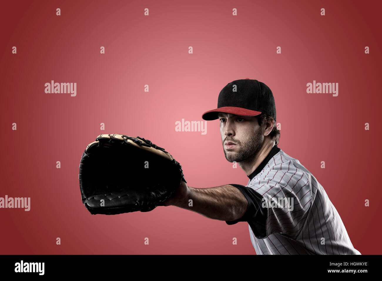 Baseball Player on a Red Uniform on red background Stock Photo - Alamy
