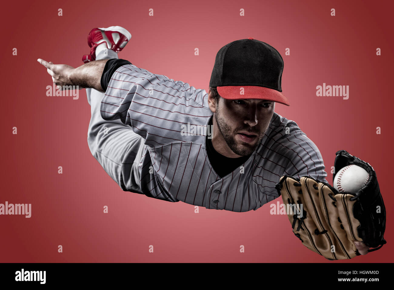 Baseball Player on a Red Uniform on red background Stock Photo - Alamy
