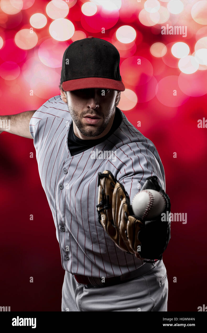 Baseball Player on a Red Uniform on red lights background Stock Photo ...