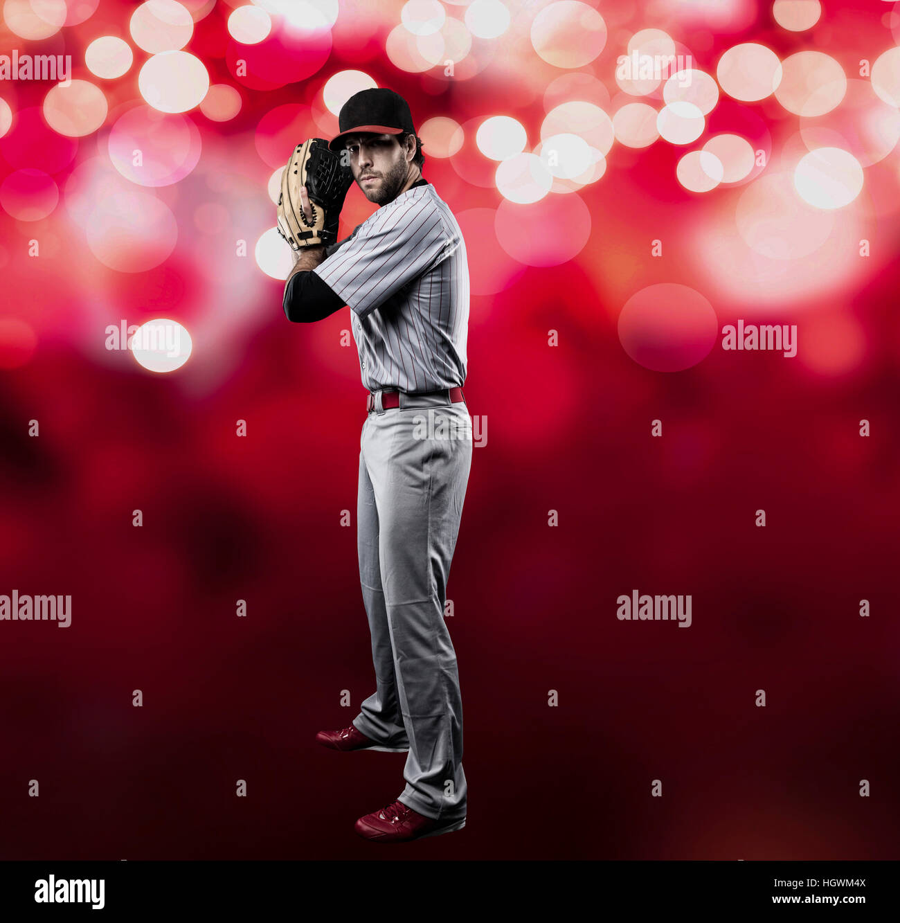 Pitcher Baseball Player on a Red Uniform on red lights background Stock ...