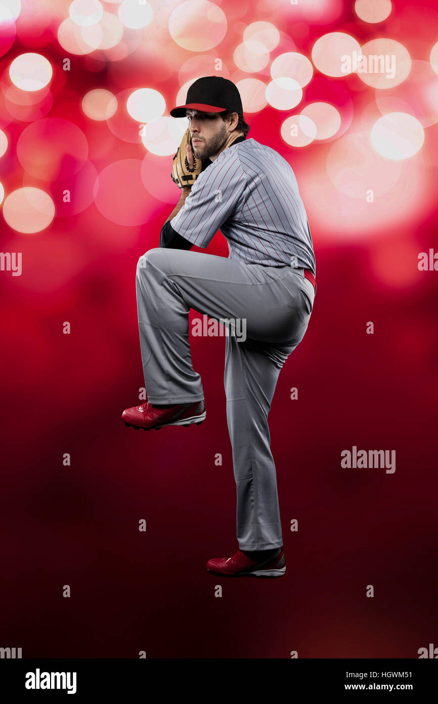 Pitcher Baseball Player on a Red Uniform on red lights background Stock ...