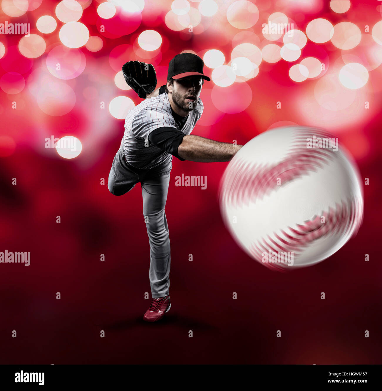 Pitcher Baseball Player on a Red Uniform on red lights background Stock ...