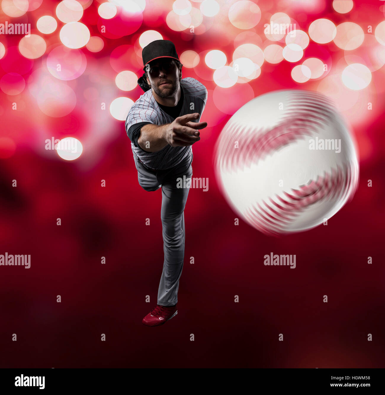 Pitcher Baseball Player on a Red Uniform on red lights background Stock ...