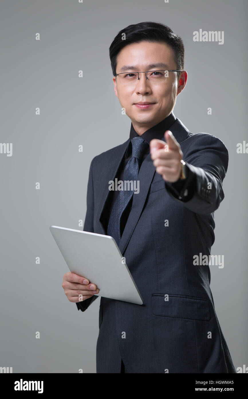 Mid adult businessman holding a digital tablet Stock Photo - Alamy