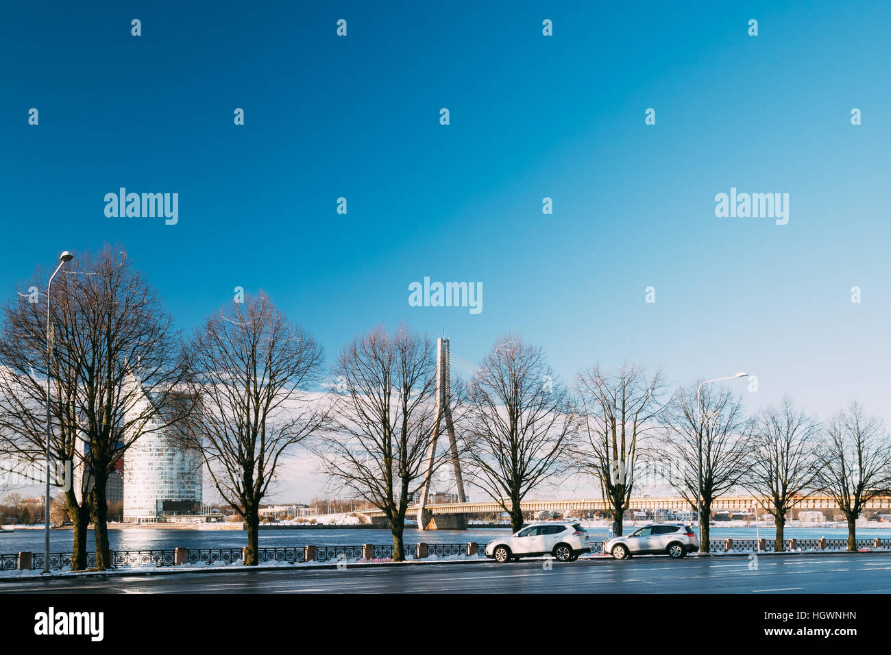 Two Cars Are Parked In Parking Lot On The Quay Of November 11 In Riga ...