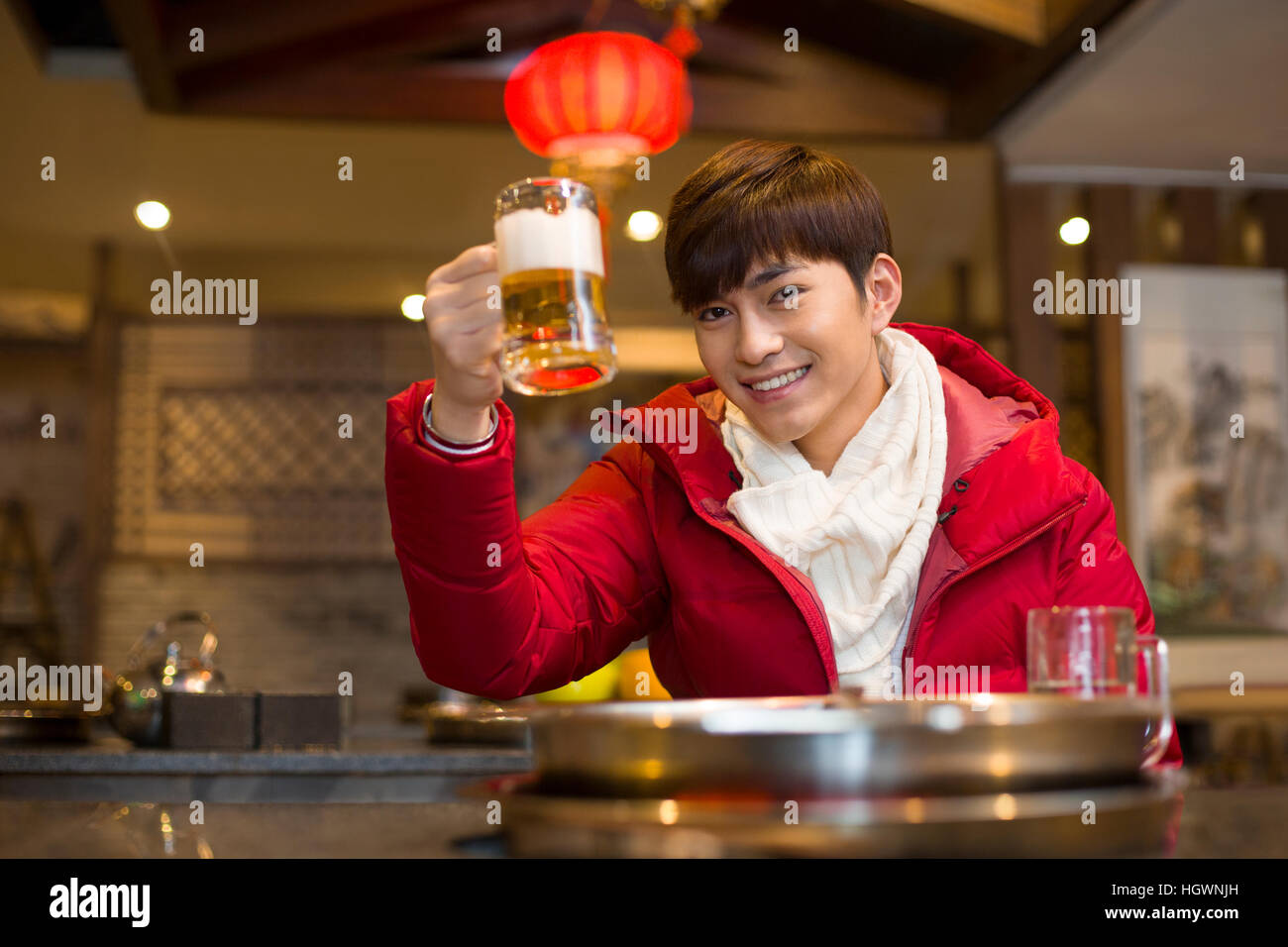 Young man drinking beer in hotpot restaurant Stock Photo - Alamy