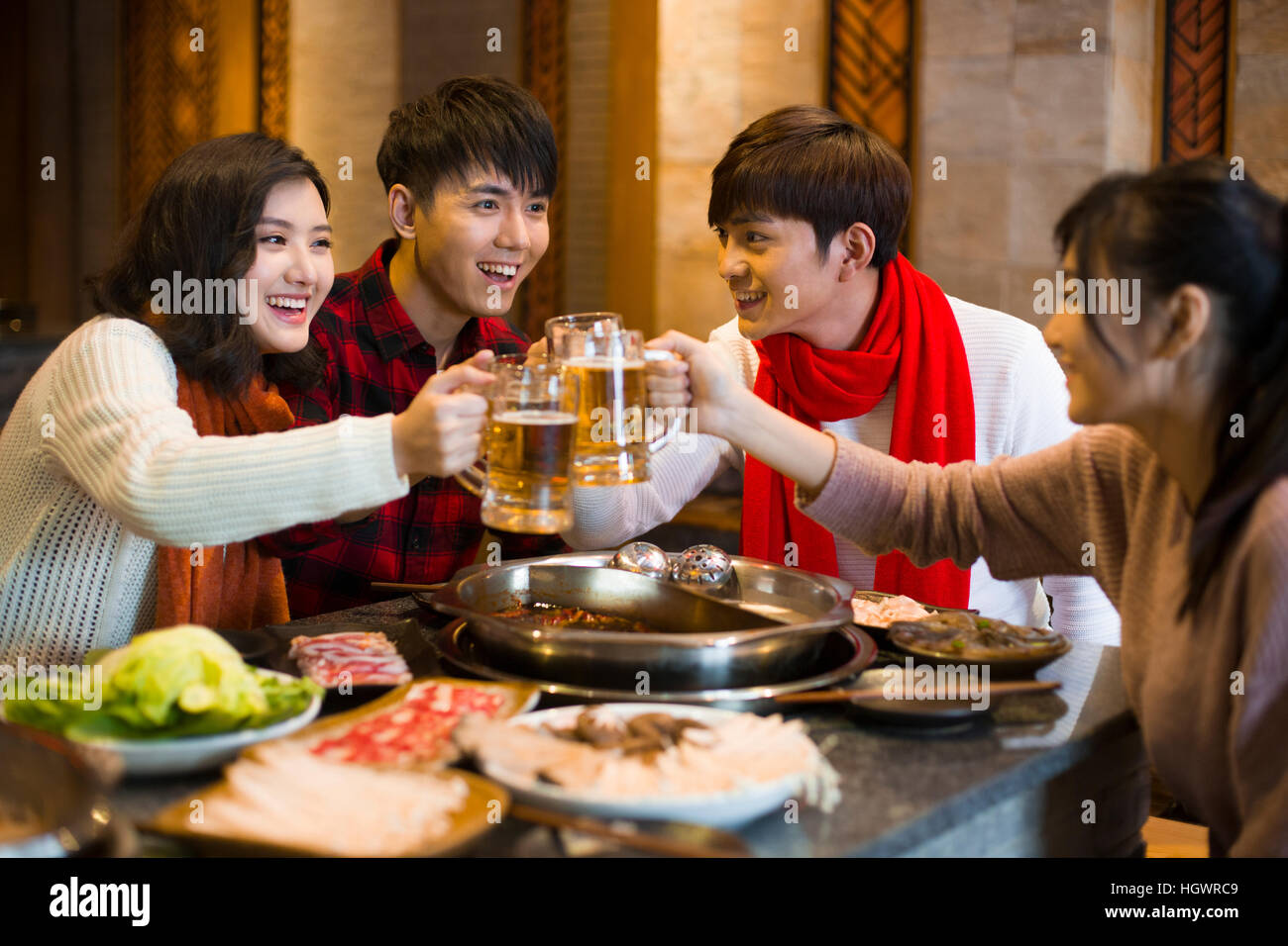 Young friends drinking beer in hotpot restaurant Stock Photo - Alamy
