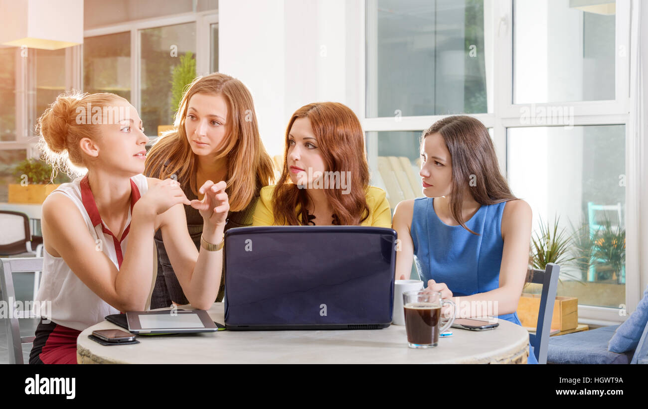 Group of four pretty businesswoman working togeather with new startup ...