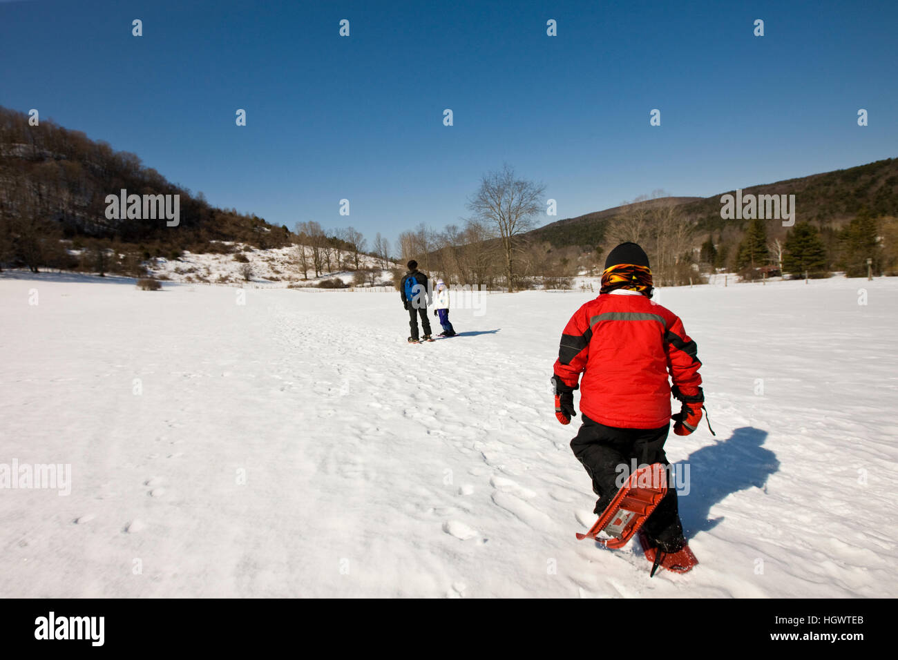 A woman and her two kids walk through a snowy field at the Tyringham ...