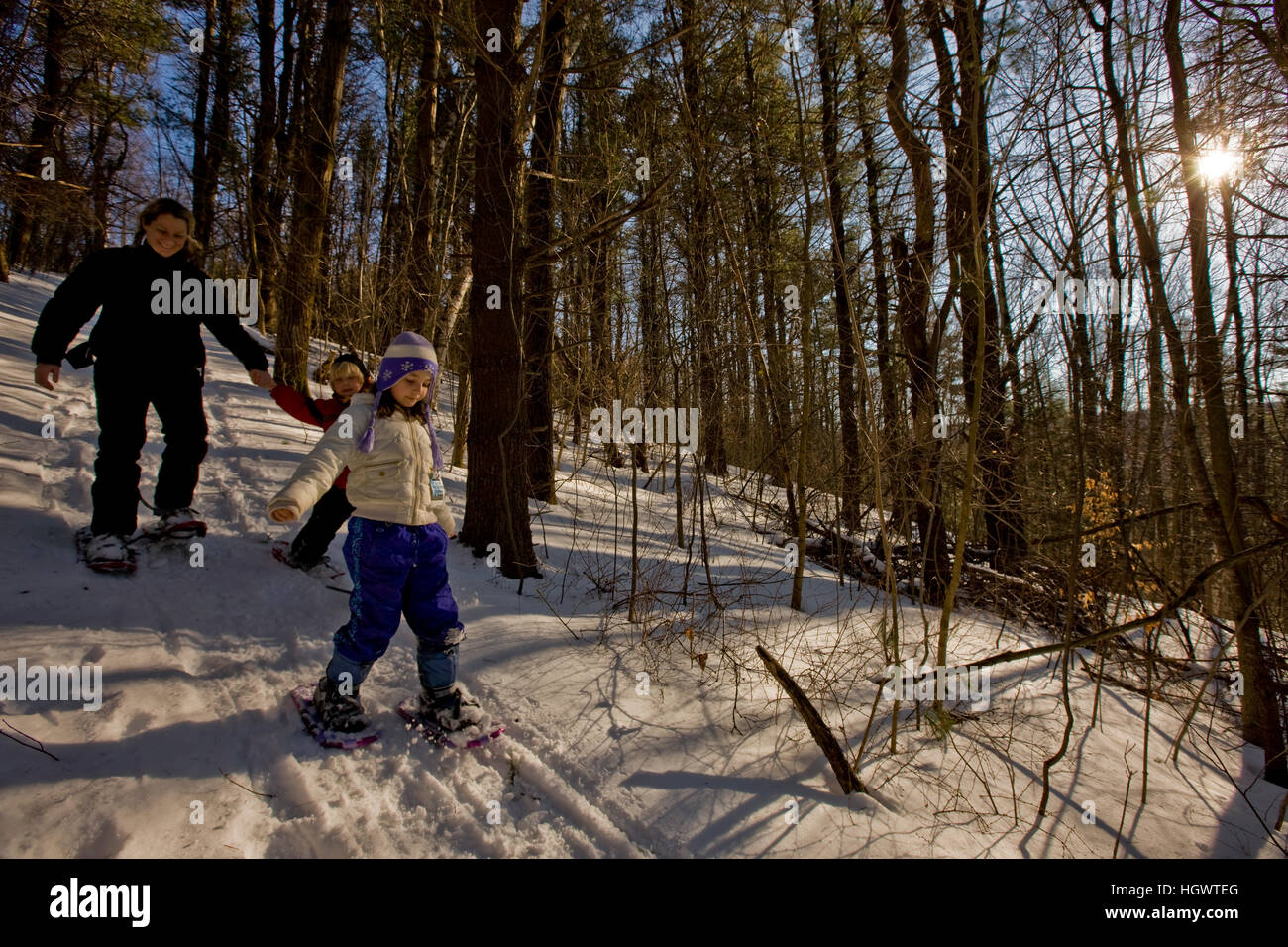 A woman and her two kids snowshoe through the woods at the Tyringham ...