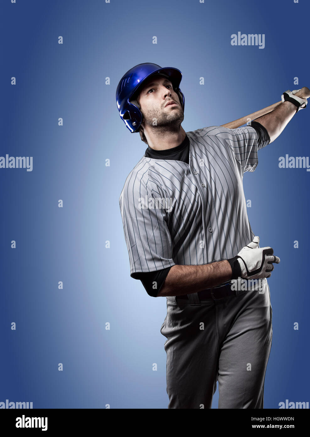 Baseball Player on a Blue Uniform on blue background Stock Photo - Alamy
