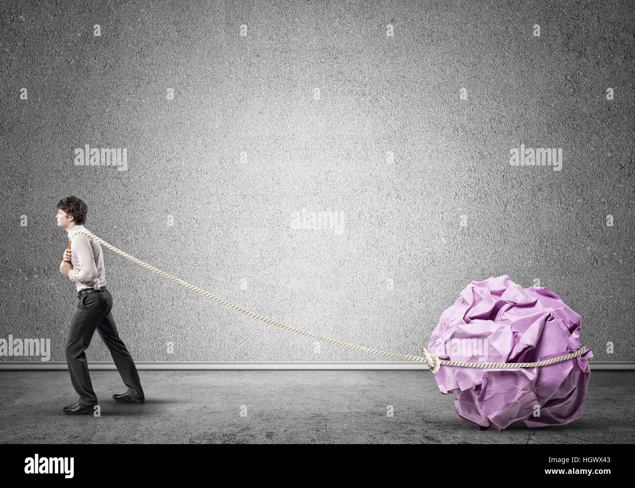 Man pulling with effort big crumpled ball of paper as creativity sign ...