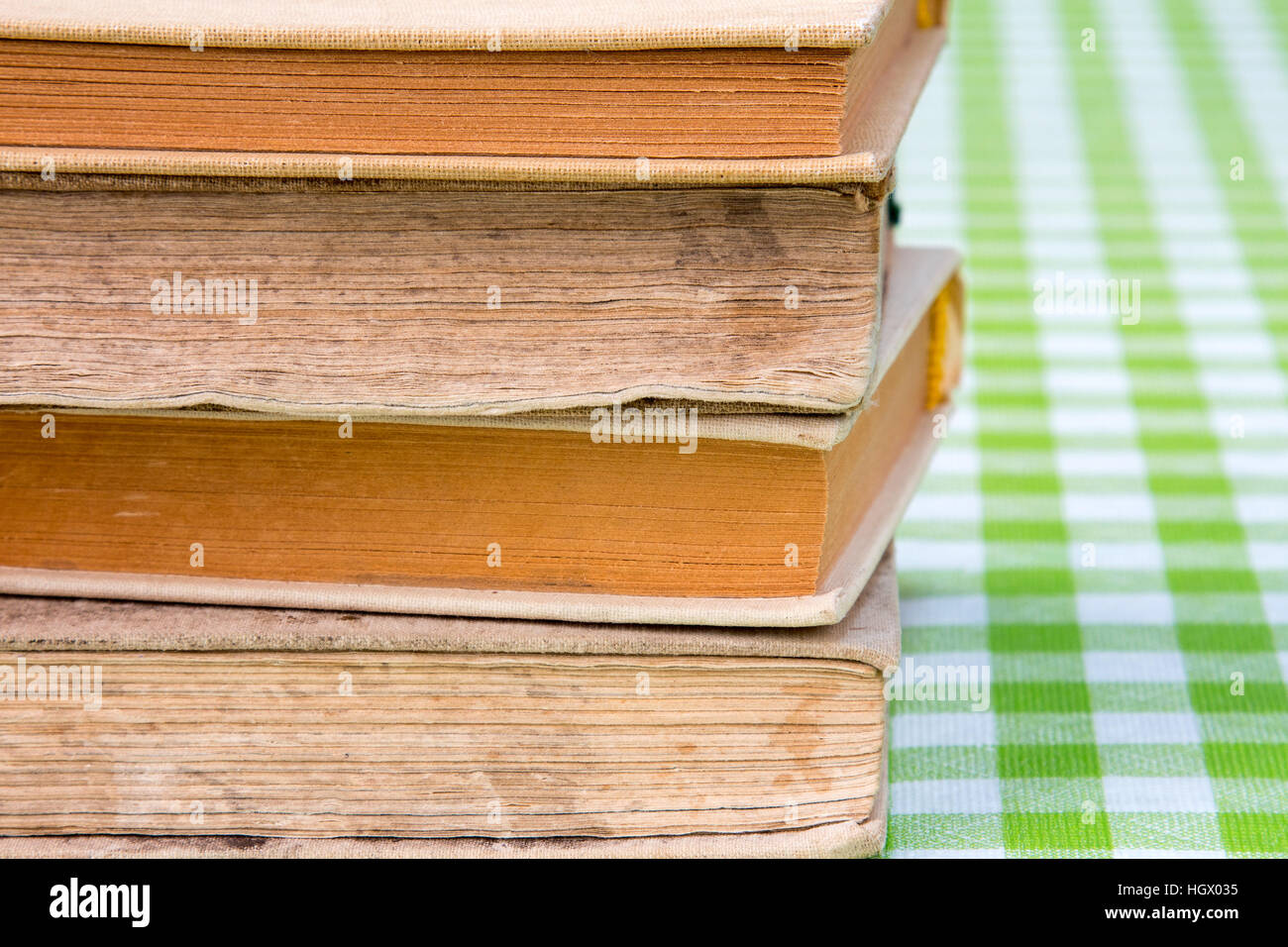 Old books stacked on top of one another, with a checkered background ...