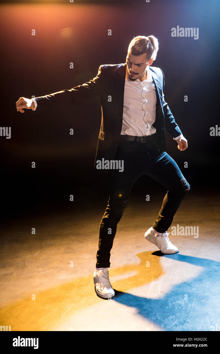 Full length portrait of handsome stylish man in black suit dancing ...