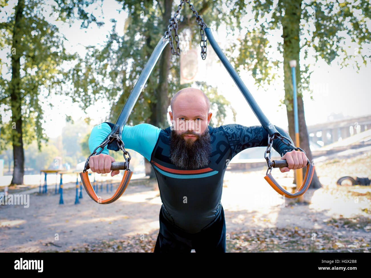 Young man training at outdoor gym in the park Stock Photo - Alamy